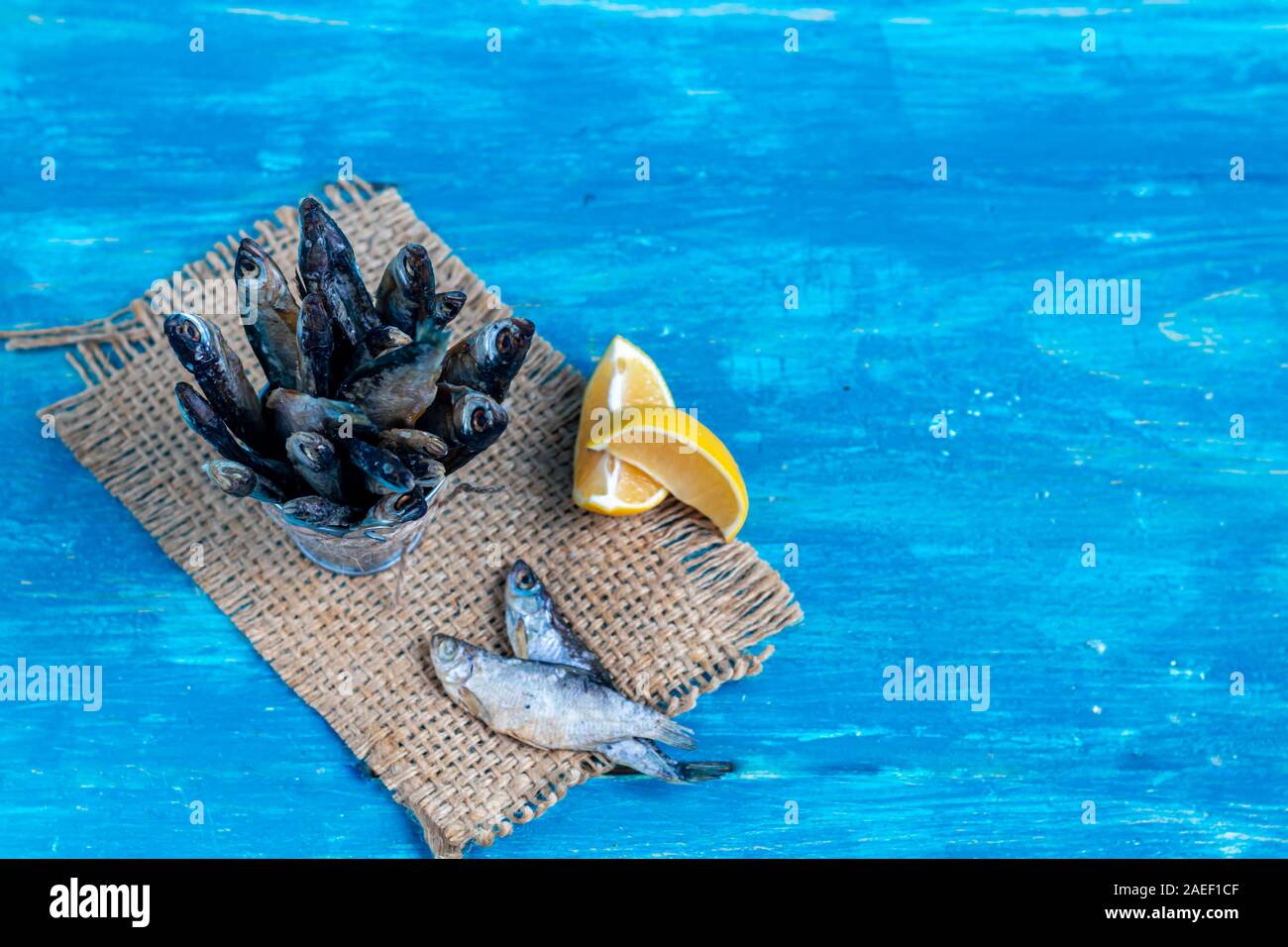 Small, salted fish. Near the slices of lemon. Sea fish. Copy space ...