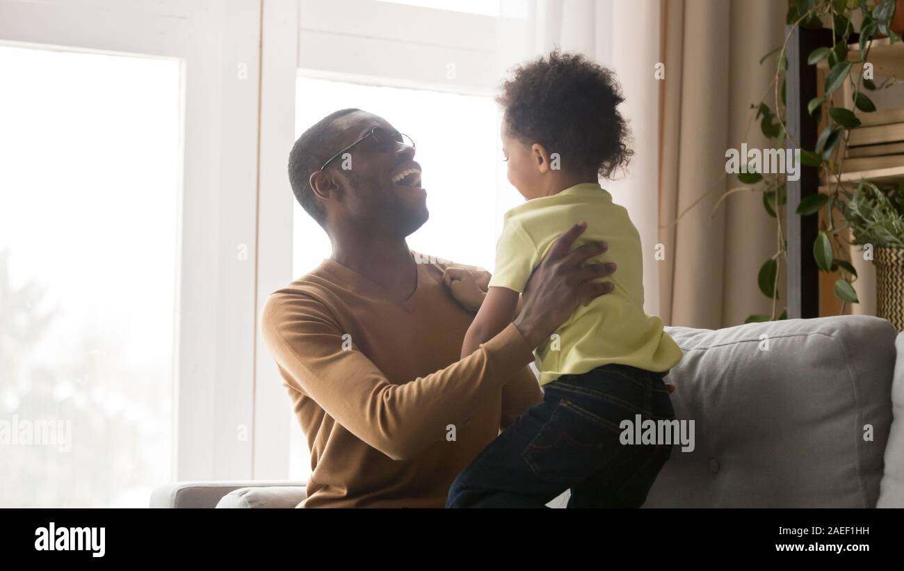 Happy black dad and son have fun playing on couch Stock Photo - Alamy