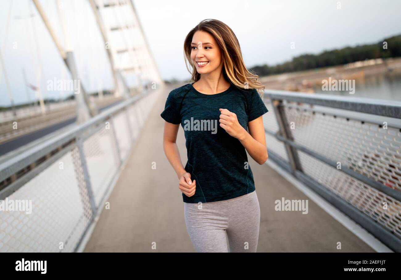 Portrait of fit and sporty young woman jogging outdoor Stock Photo - Alamy