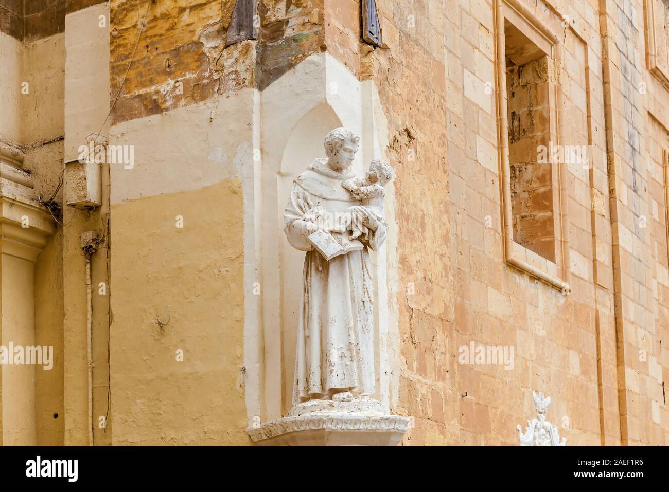 An old medieval sculpture with the figure of a saint in full height ...