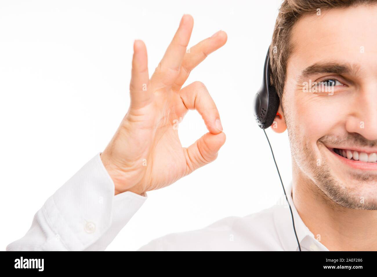 Portrait of cute smiling agent of call-centre, showing "OK" gesture ...
