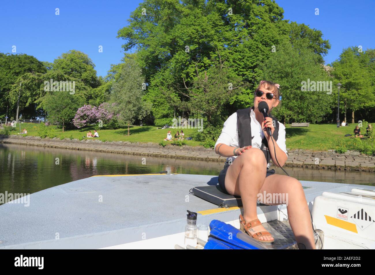 A tour guide talks into a microphone and provides information to ...