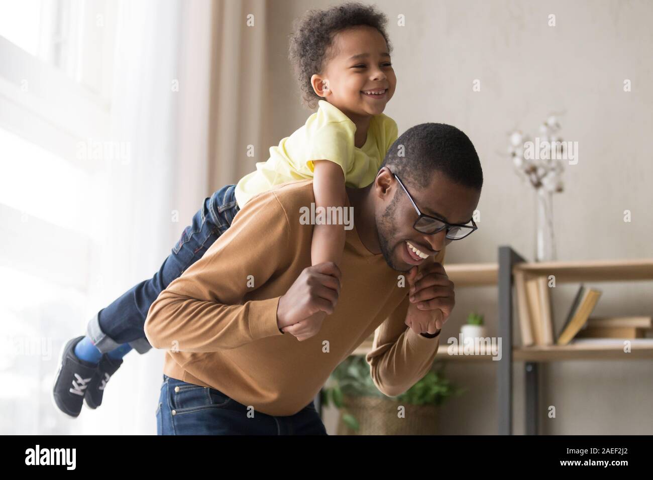 Smiling preschooler boy piggyback playing with dad Stock Photo - Alamy