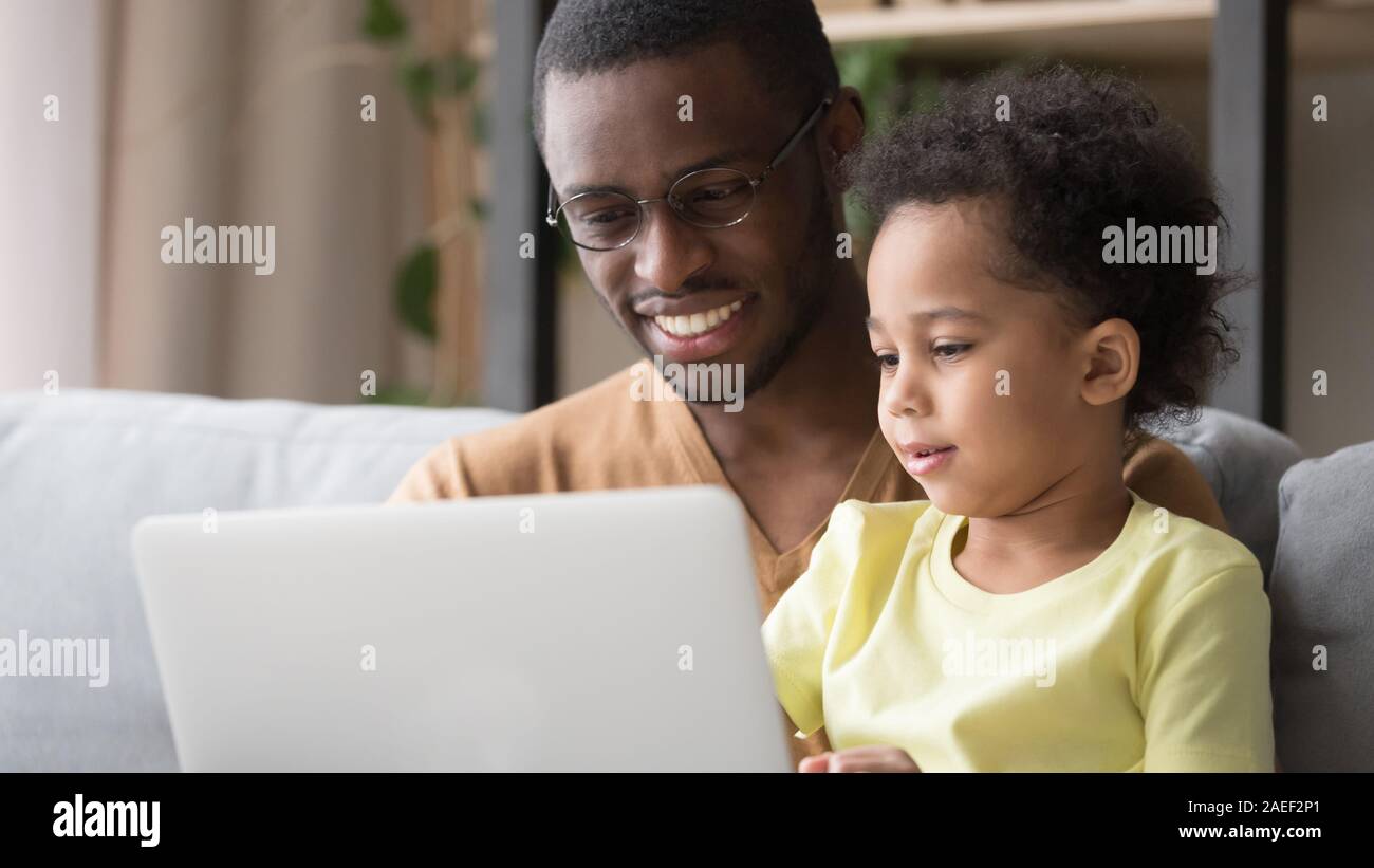 Close up of smiling black dad and son using laptop Stock Photo - Alamy