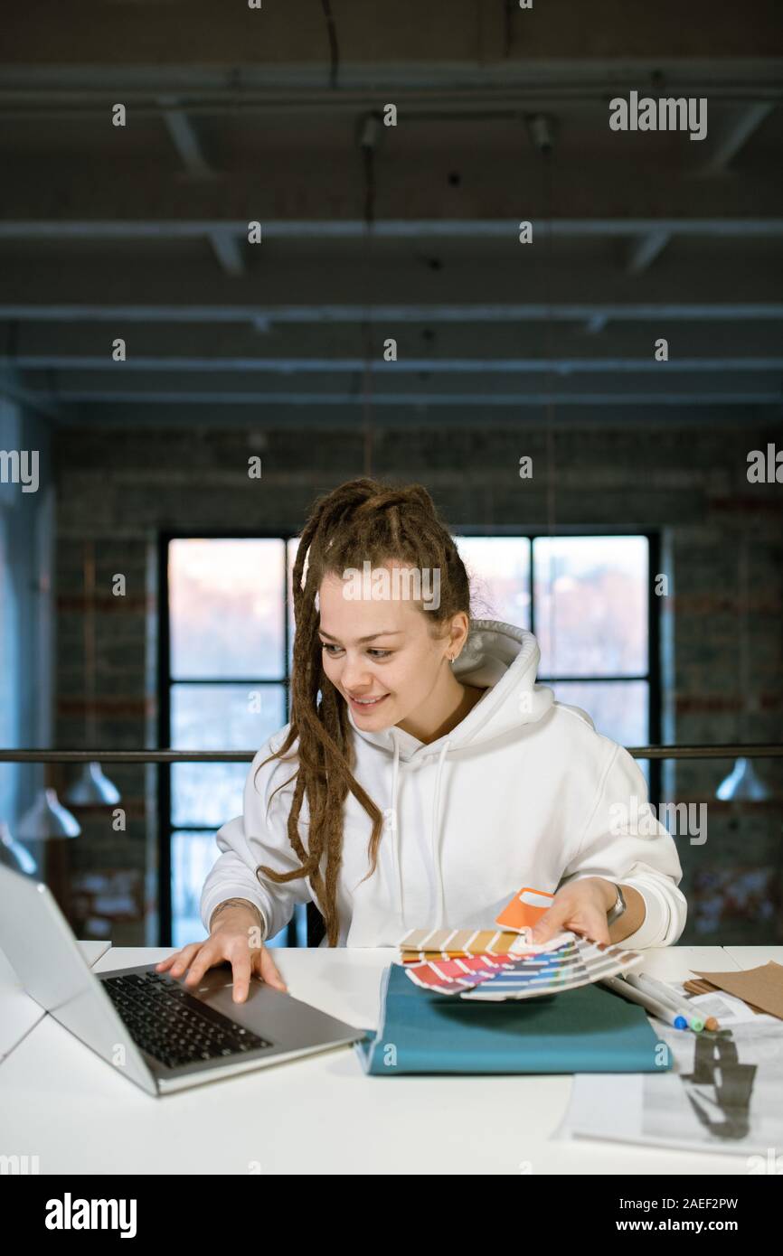 Successful young creative designer with color palette working in studio ...