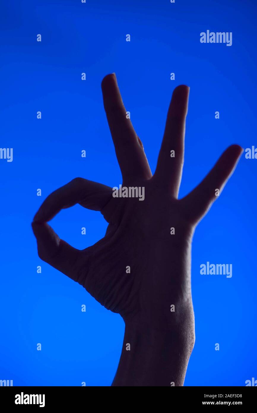 Okay black symbol in front of blue background Stock Photo - Alamy