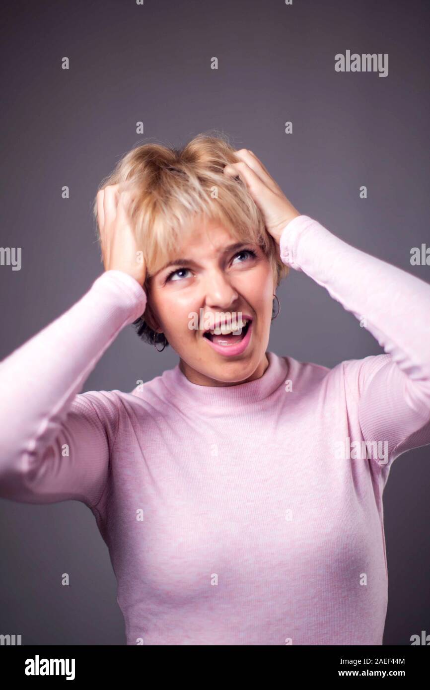 Woman with short blond hair feeling angry. People and emotions concept ...