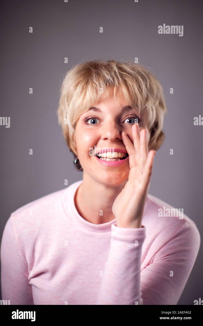 Woman with short blond hair showing gossip gesture. People and emotions ...