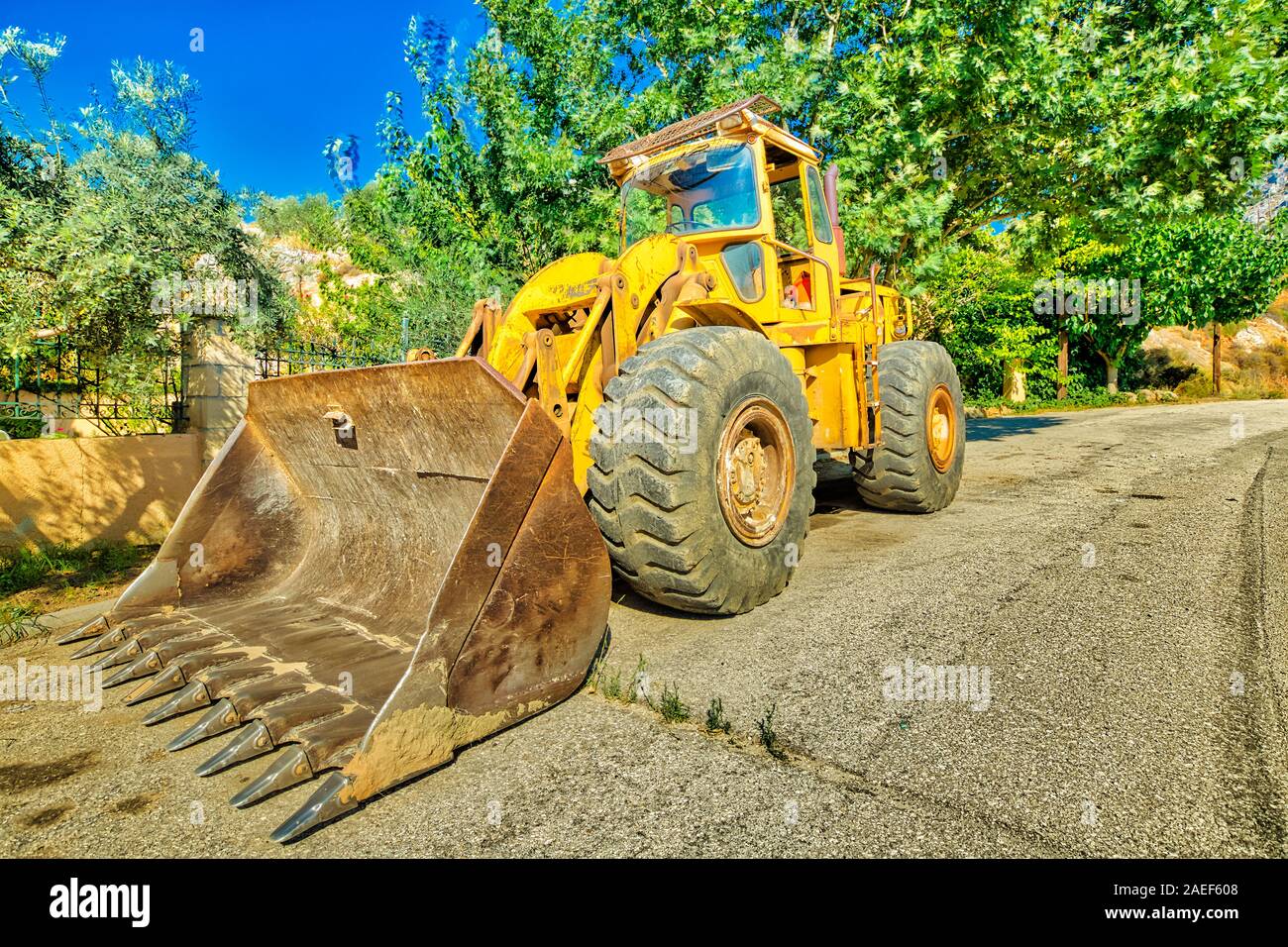 Side view of yellow bulldozer on wheels for building work on a road ...