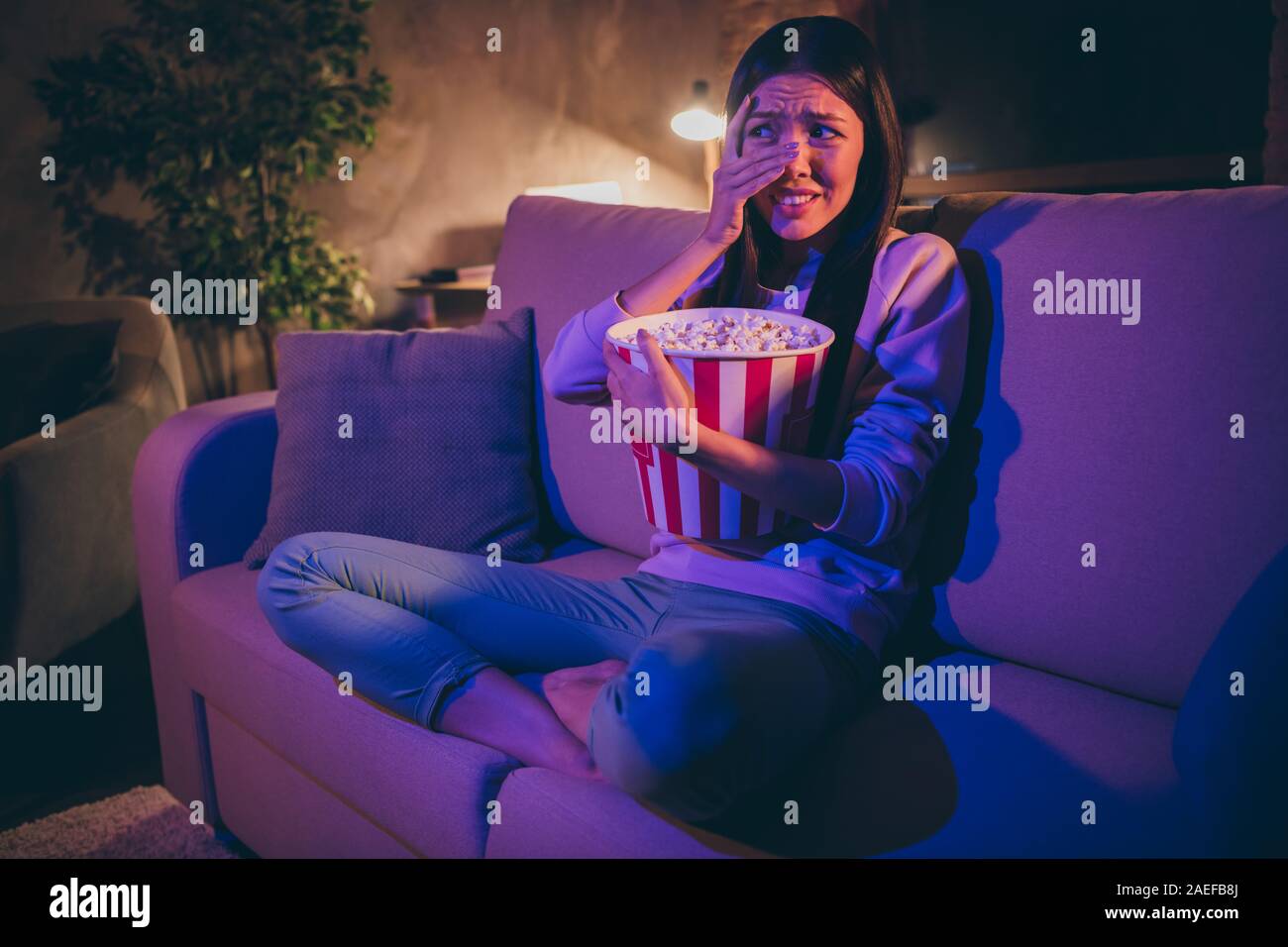 Photo of homey chinese lady eat popcorn movie night watch horror scary ...