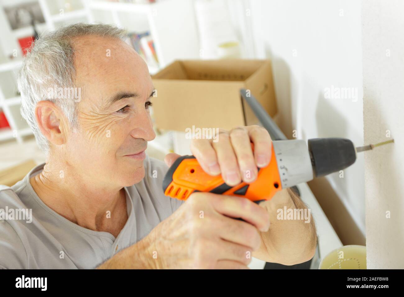 senior working with drill wall Stock Photo - Alamy