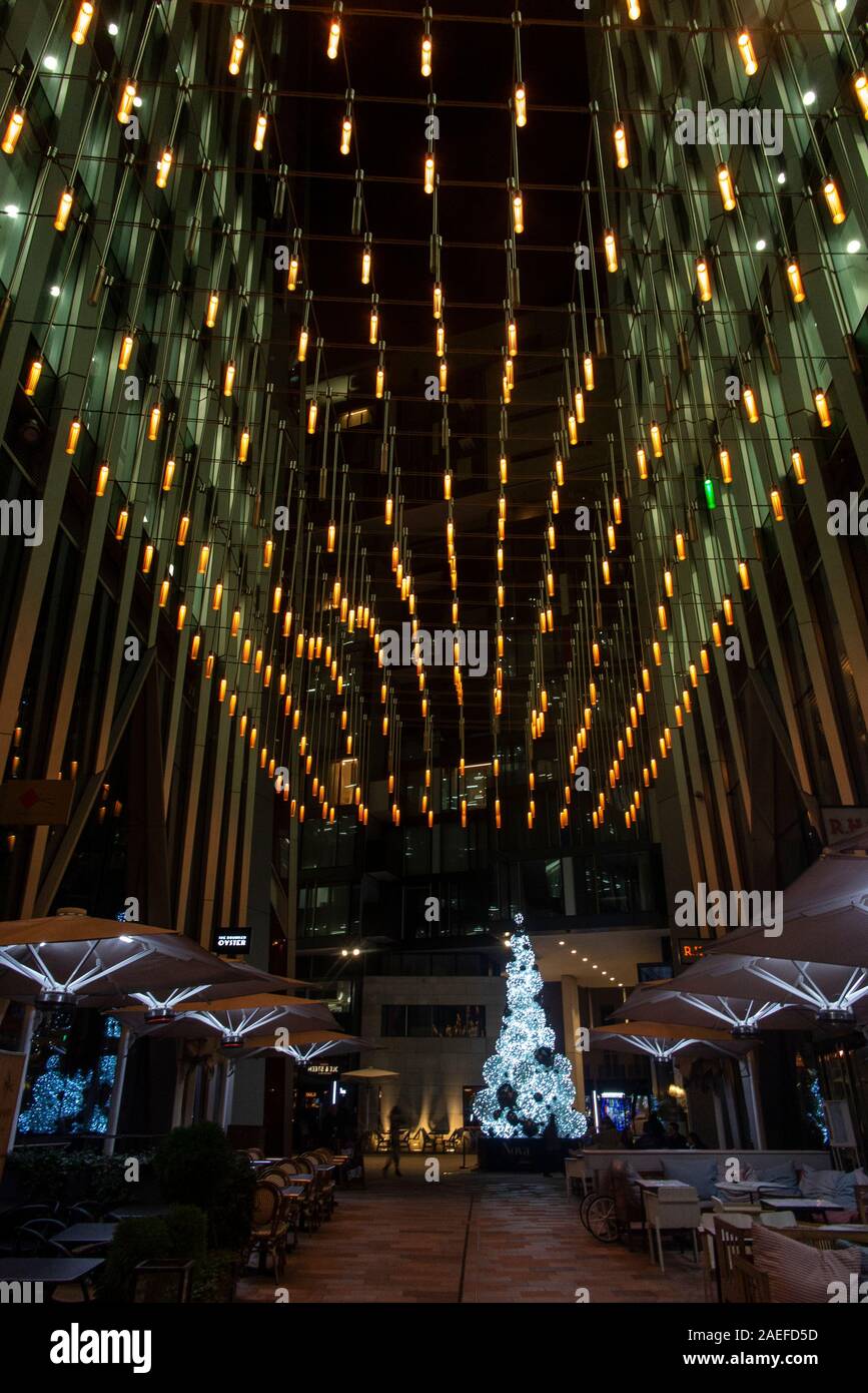 A Christmas tree with lights above the restaurants and shops in the ...