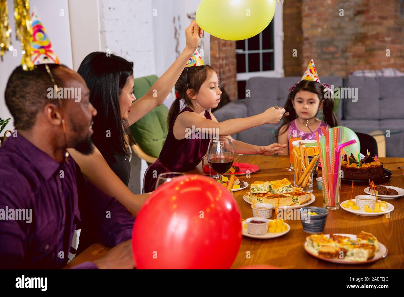 Portrait of happy multiethnic family celebrating a birthday at home ...