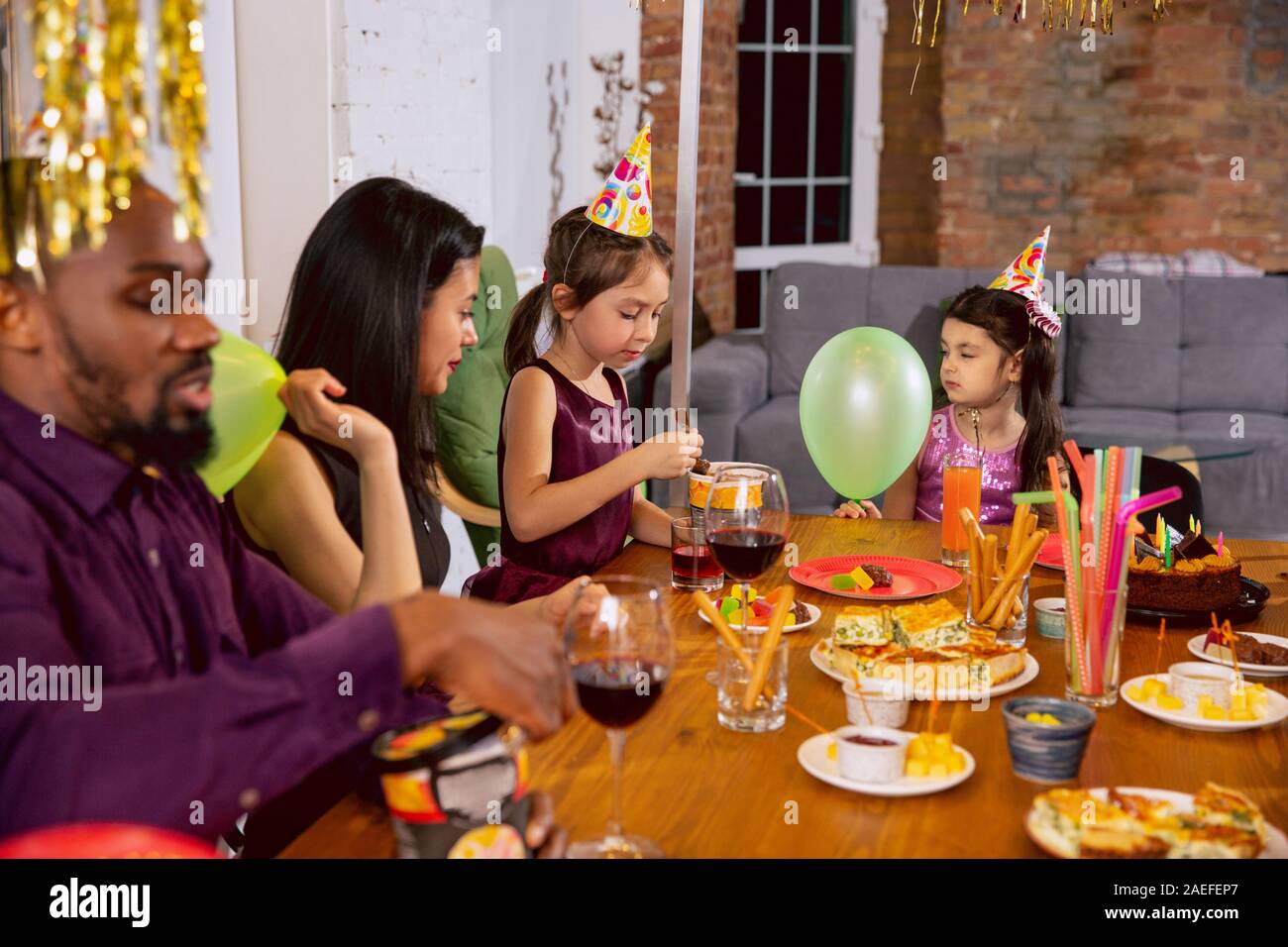 Portrait of happy multiethnic family celebrating a birthday at home ...