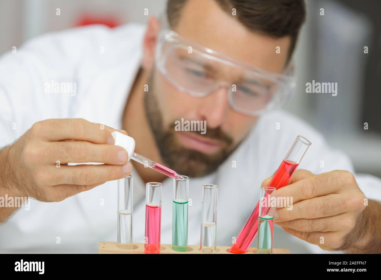 scientist dripping liquid into the test tube Stock Photo - Alamy