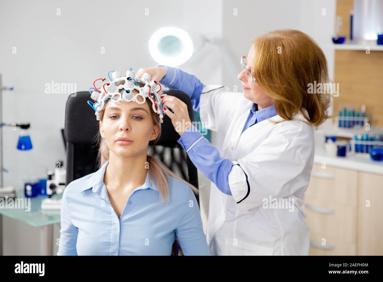 Doctor adjusting scanning device on the head of a female patient ...