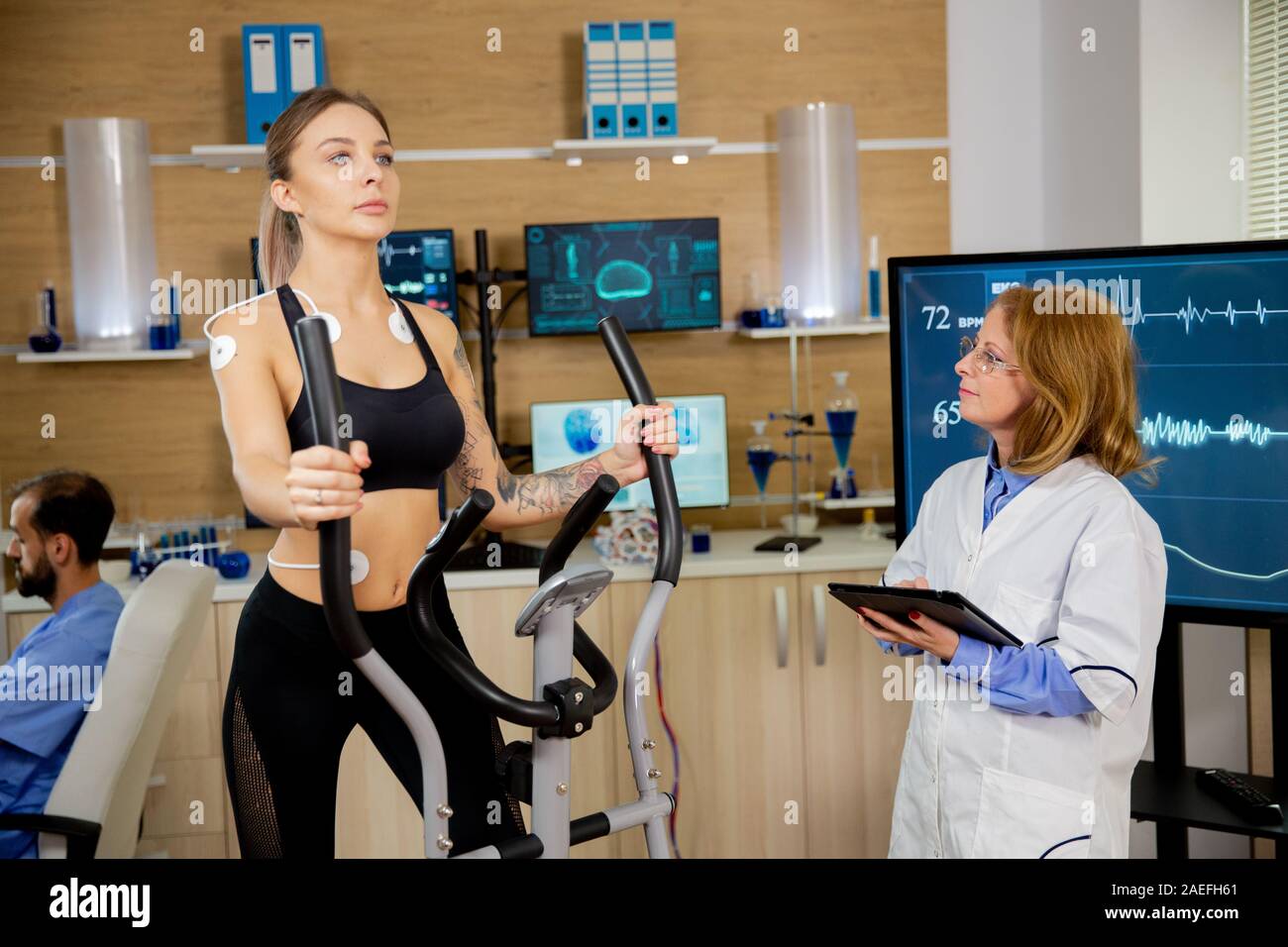 Female athlete who runs tests on the stepper and the doctor follows her ...