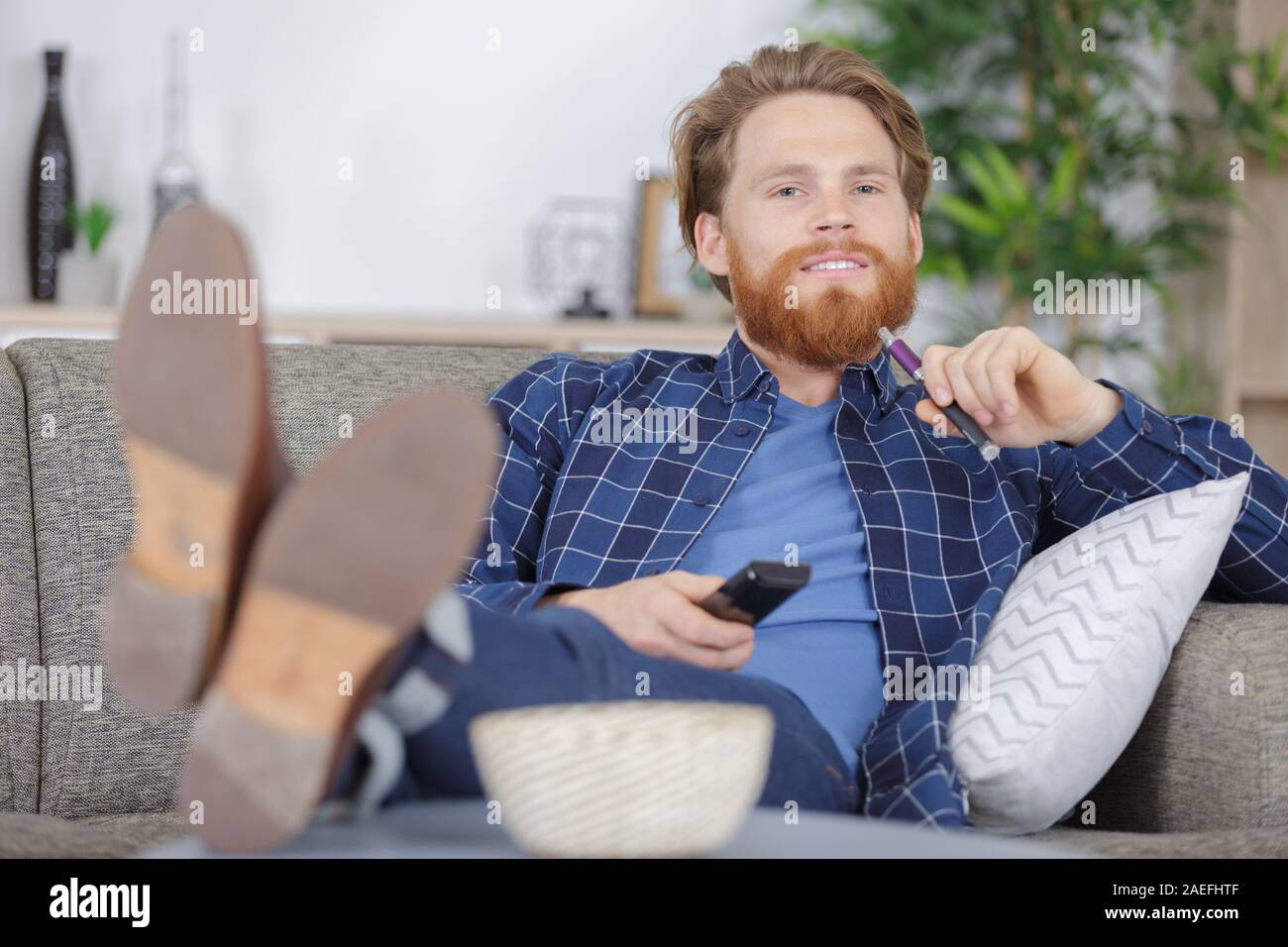 a man with tv remote Stock Photo - Alamy