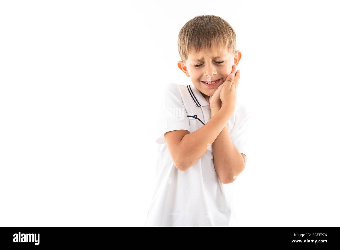 sad boy with bangs in a white t-shirt on a white background with copy ...