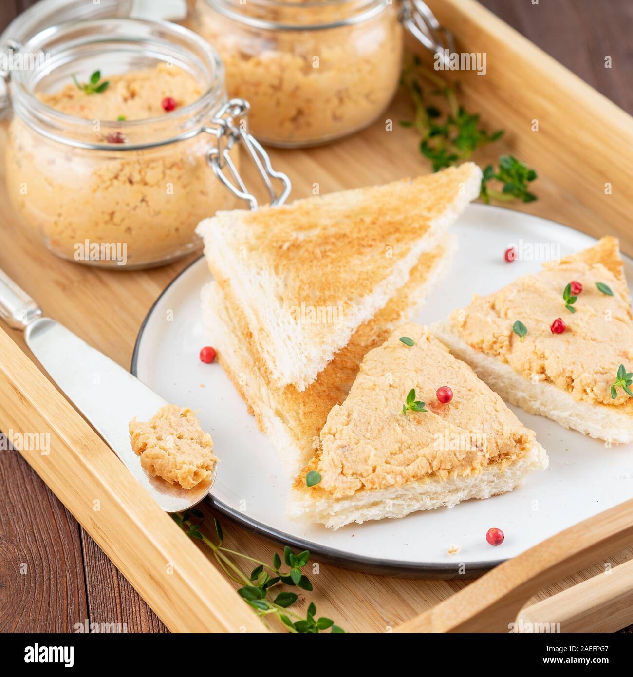 Fresh homemade chicken pate on a toasted bread on tray over rustic ...