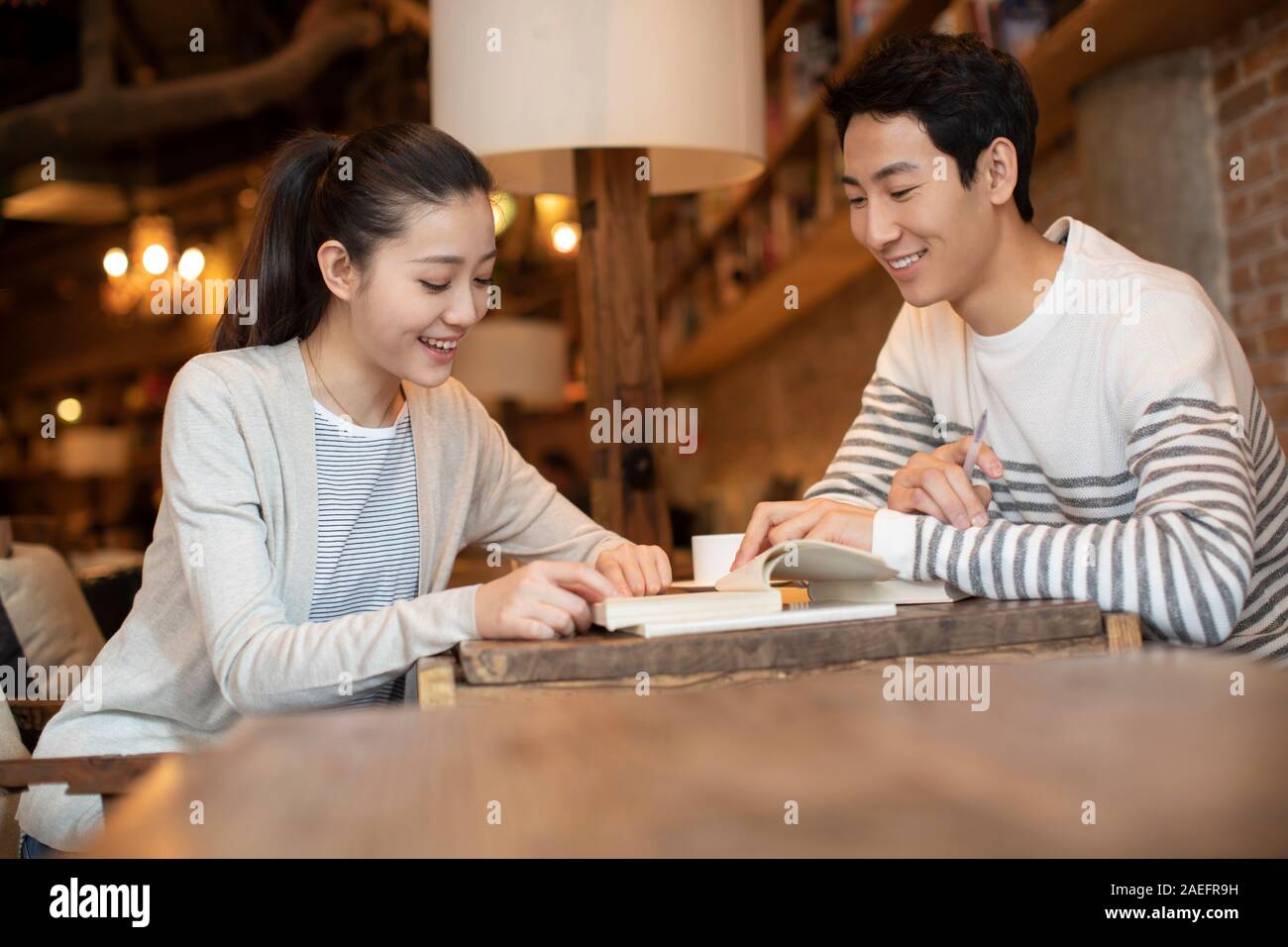 Young university students studying in coffee shop Stock Photo - Alamy