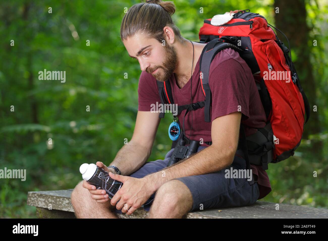 hiker sitting on a rock looking down Stock Photo - Alamy