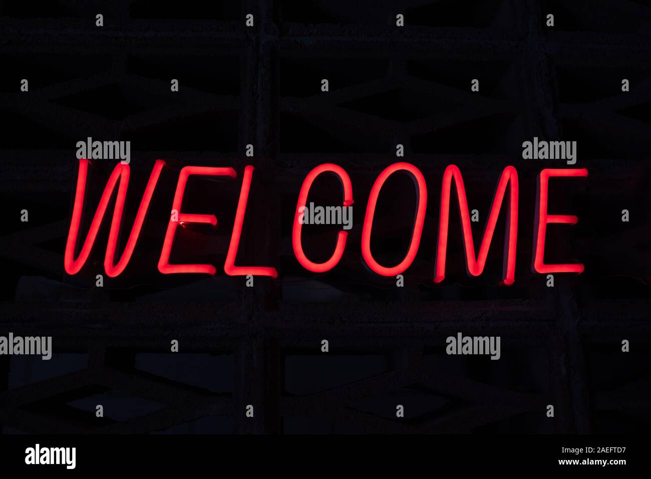Red color neon glowing sign text welcome on black background. Made from ...
