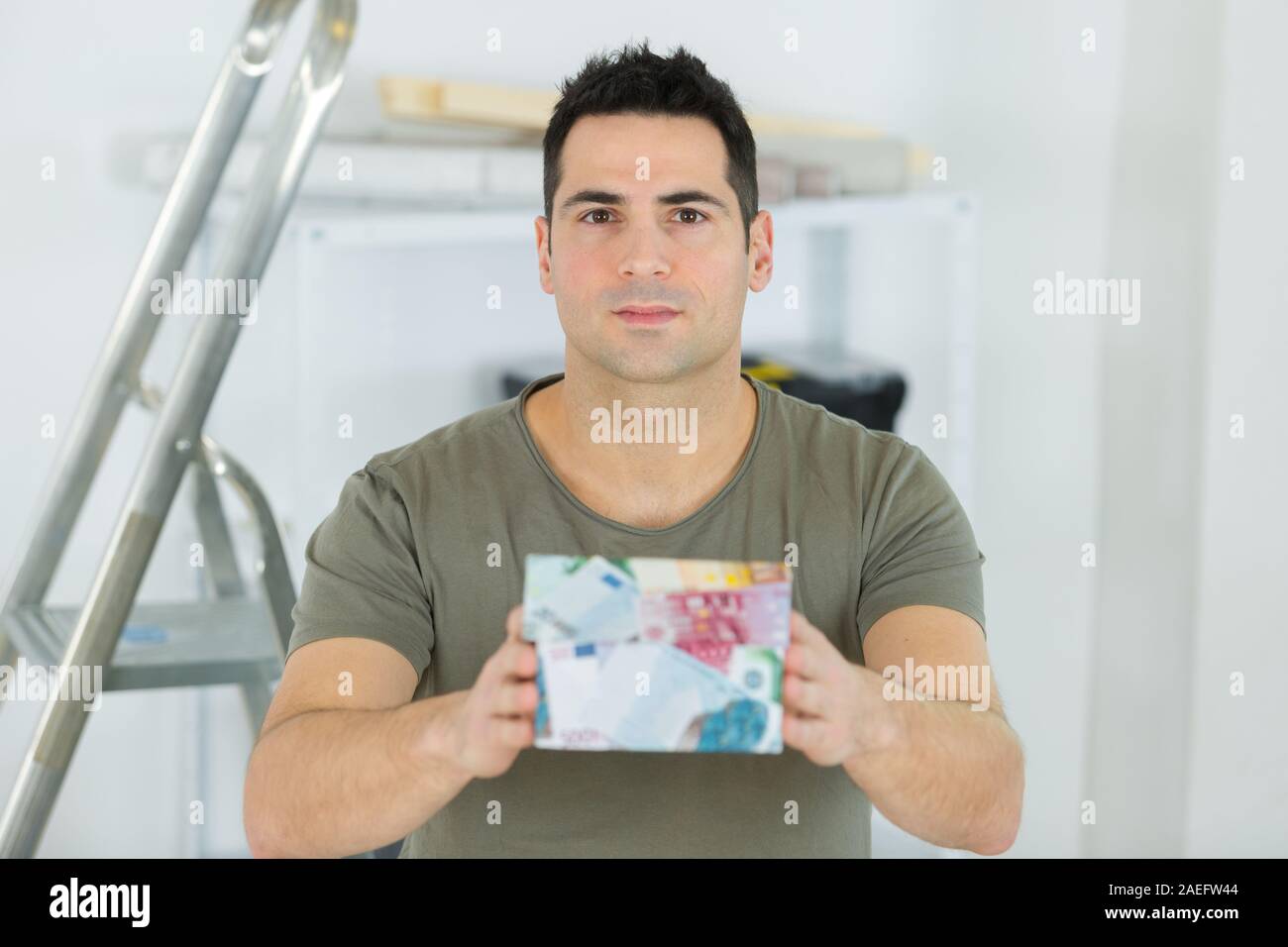 man holding a symbol of saving from diy Stock Photo - Alamy