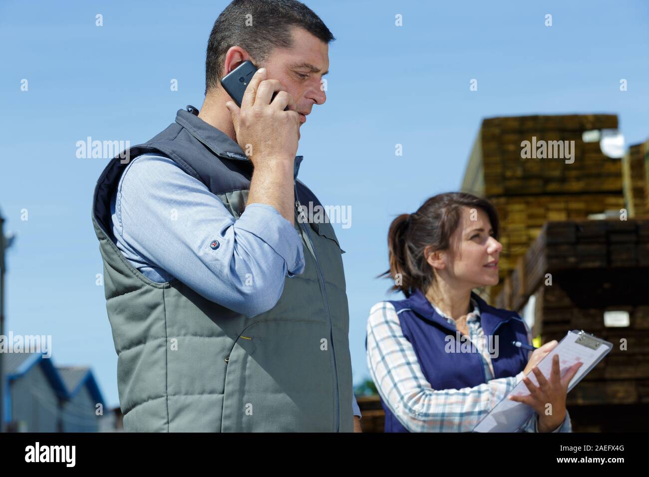 man talking on phone outside a wood factory Stock Photo - Alamy