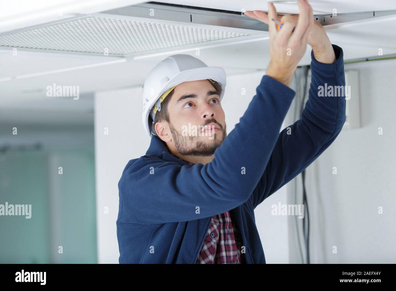 a builder replacing ceiling panel Stock Photo - Alamy