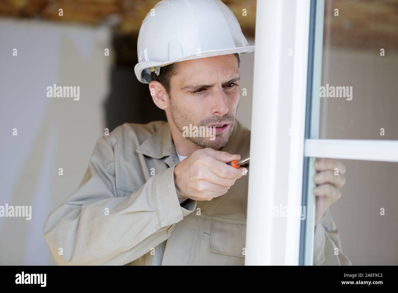 young construction worker fitting a window Stock Photo - Alamy
