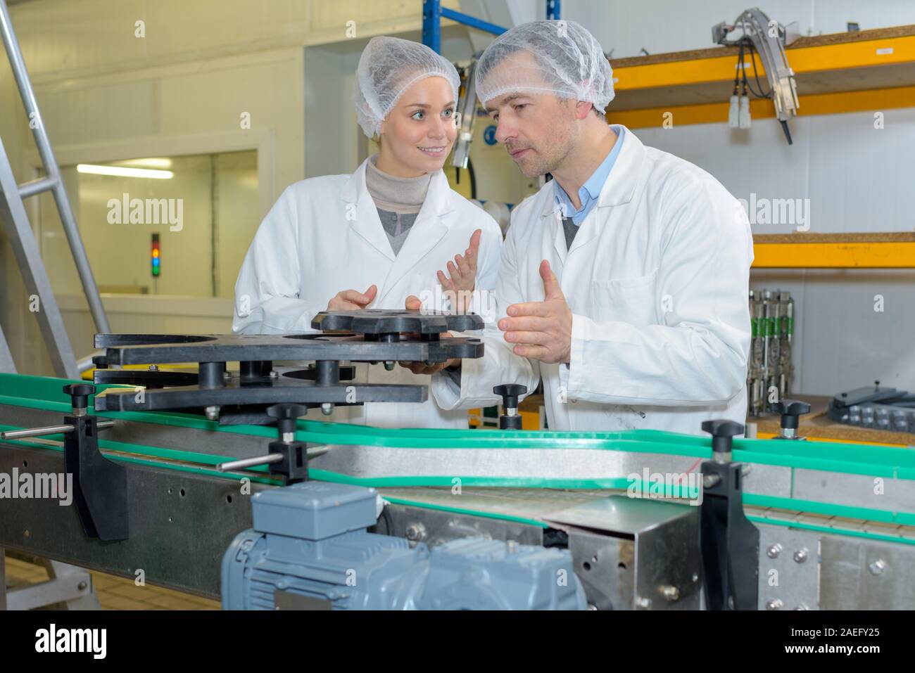workers in the food production on a machine Stock Photo - Alamy