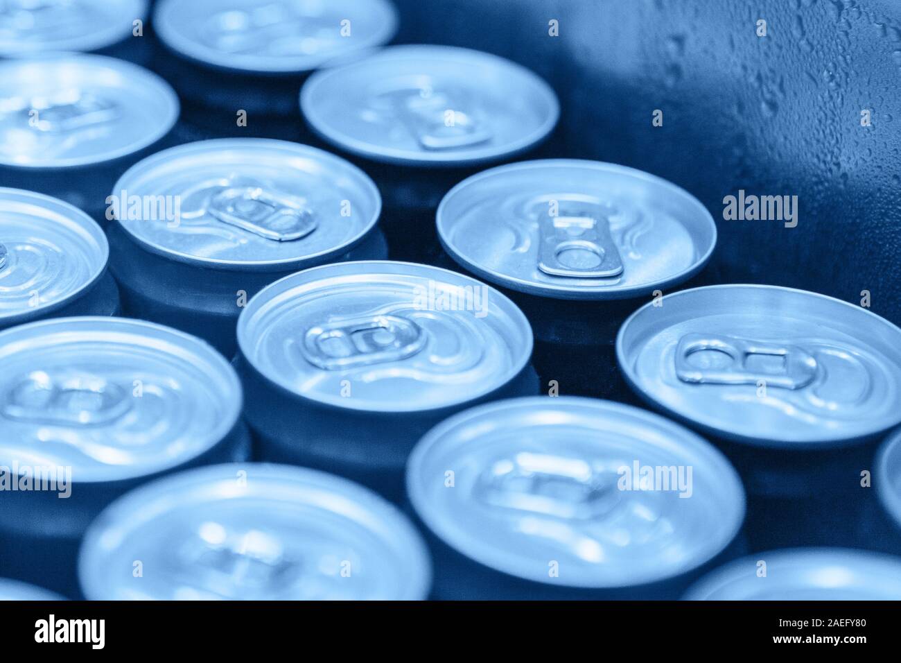 Many metal cans with cool drinks in trendy classic blue color ...