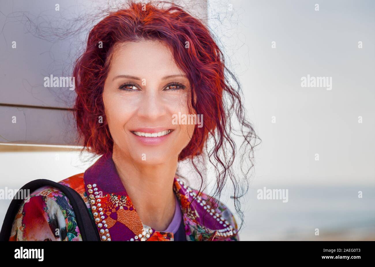 mature woman with mediterranean facial features wearing colorful dress ...