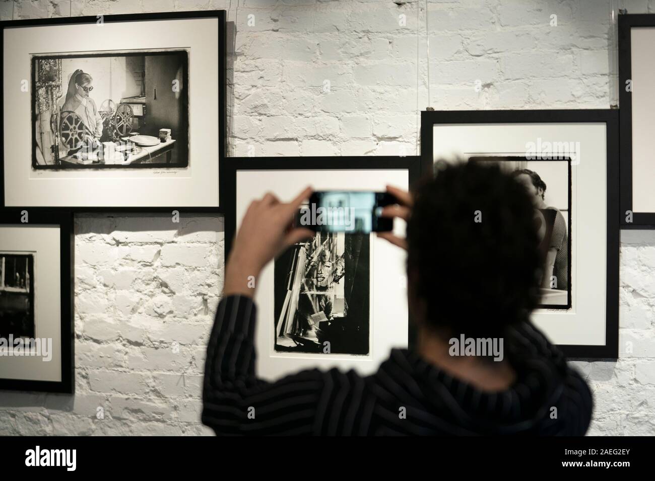 A gallery assistant takes a reference picture of unique signed and ...