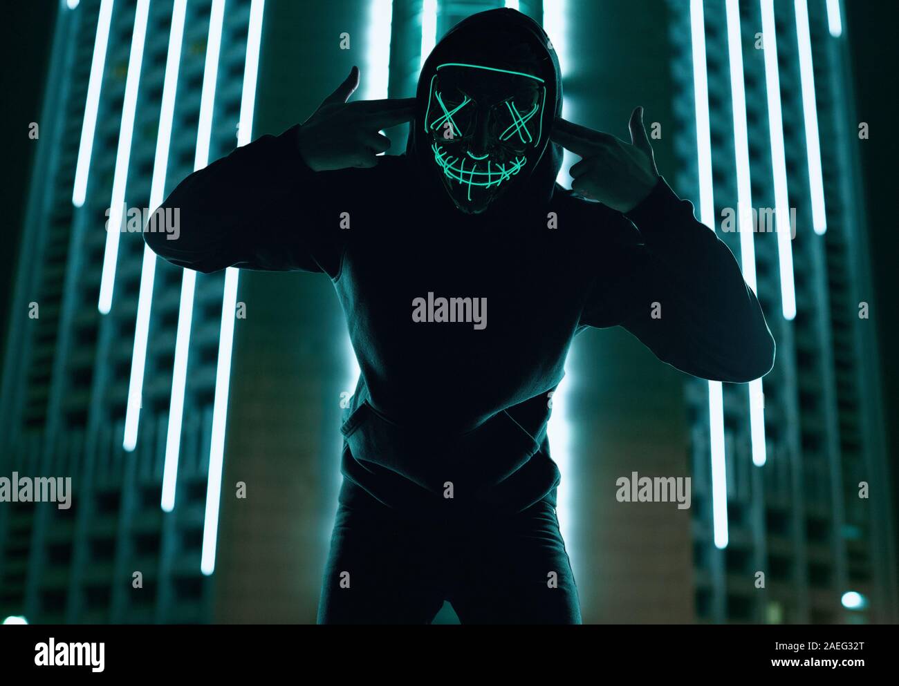Portrait of an anonymous man in a black hoodie hiding his face behind a ...
