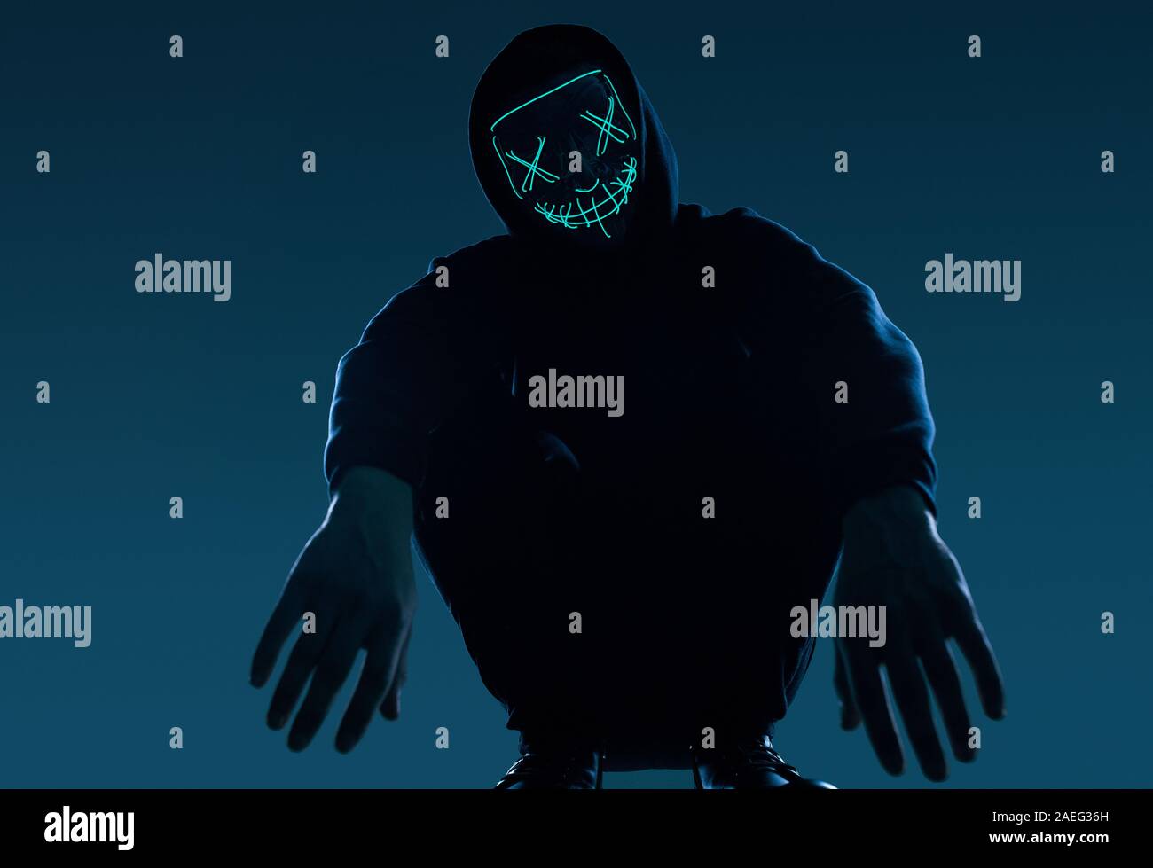 Portrait of an anonymous man in a black hoodie hiding his face behind a ...