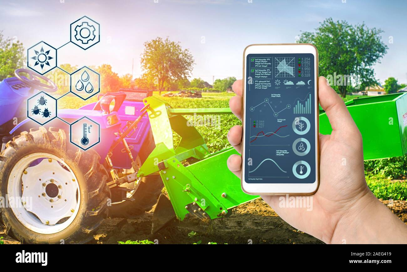 Farmer holds smartphone with infographic on tractor background with ...