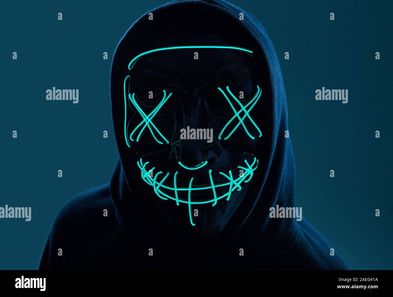 Portrait of an anonymous man in a black hoodie hiding his face behind a ...