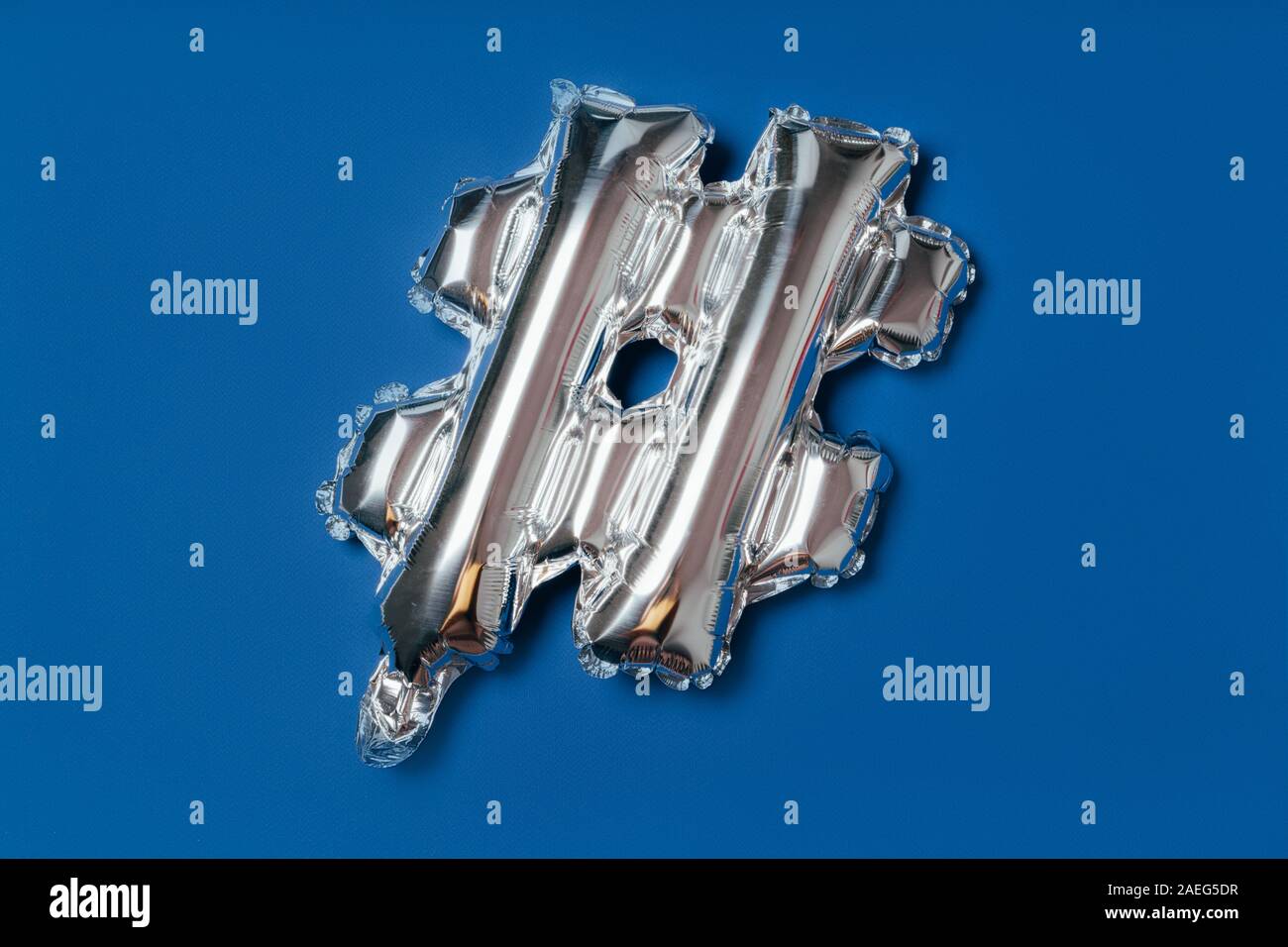 Silver hashtag inflatable balloon on a blue background Stock Photo - Alamy