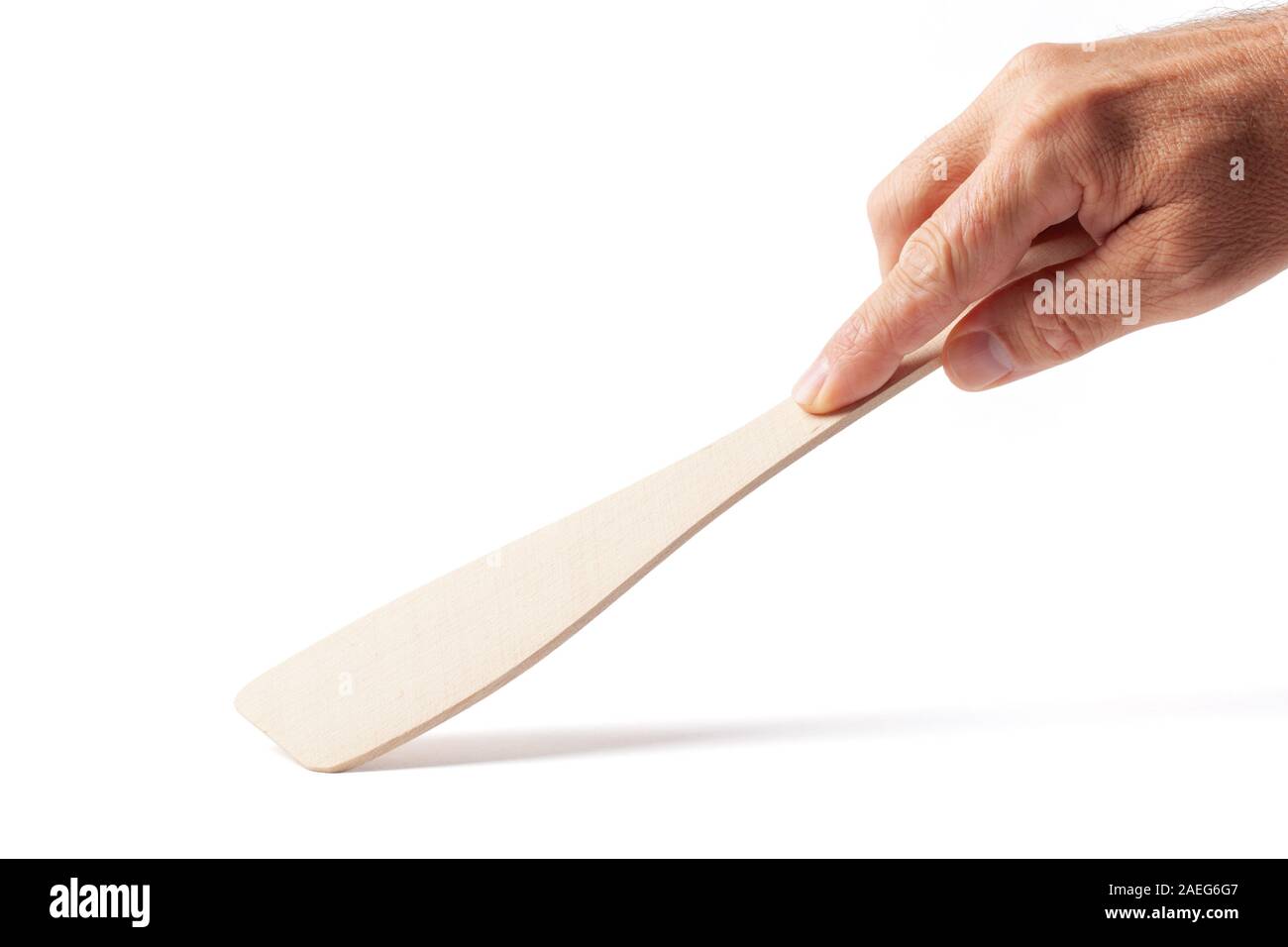 New wooden cooking spatula in a human hand isolated on white. Image ...