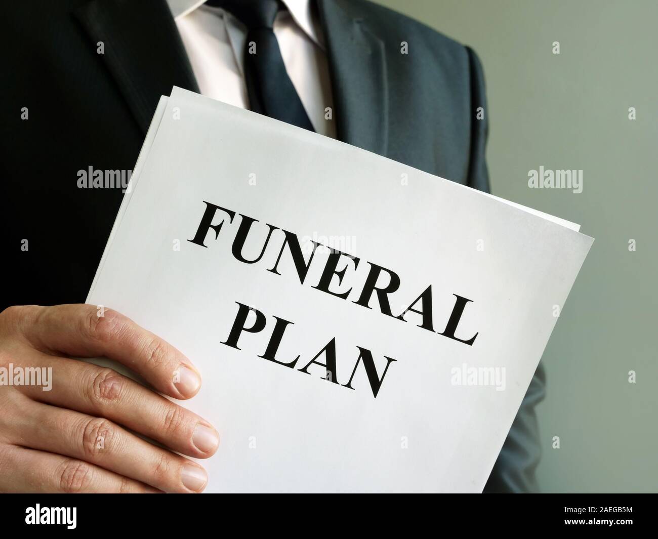 Man holds Funeral plan and stack of papers Stock Photo - Alamy