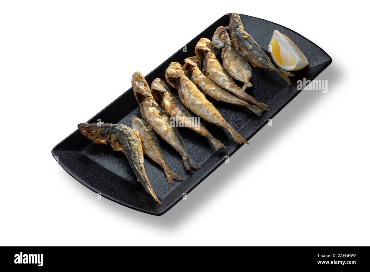Delicious fried small fish with lemon in modern black plate Stock Photo ...