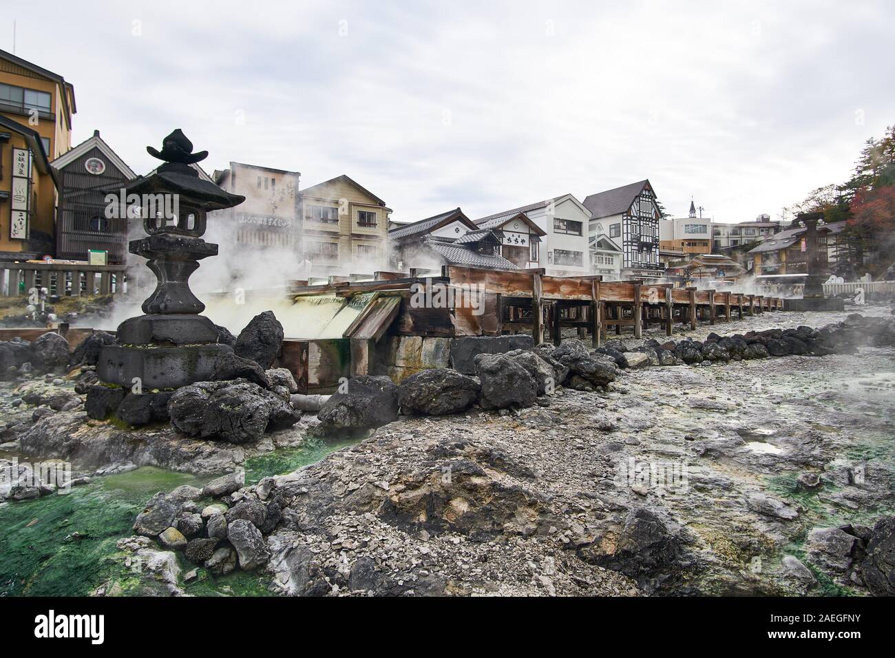 Wide view of the flowing sulfurous water and stone lantern at the hot water field (Yubatake) at ...