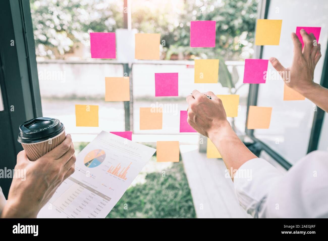 Business people meeting at office and use sticky notes on glass wall in ...