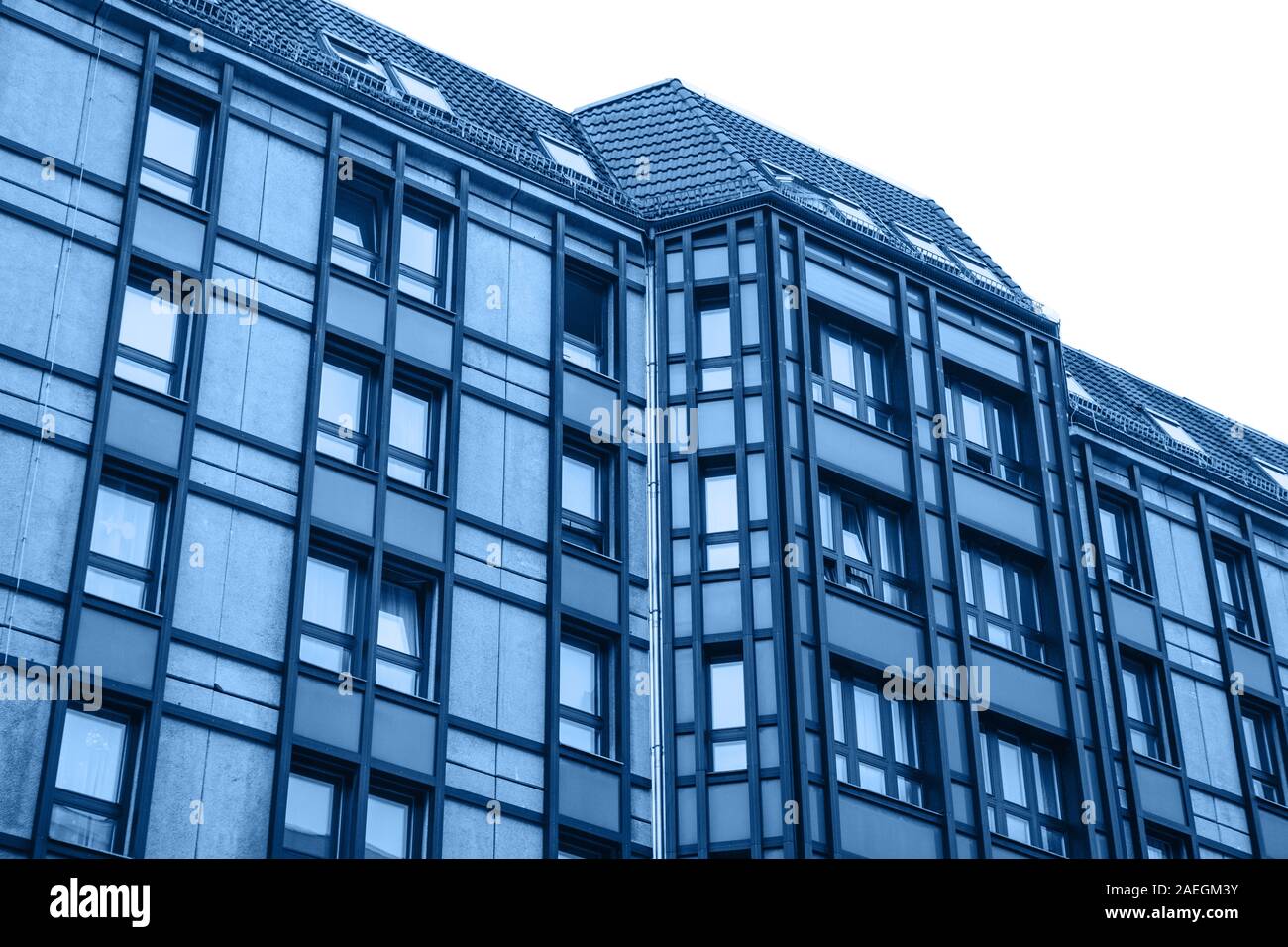 A residential building in trendy classic blue color with cut out sky ...