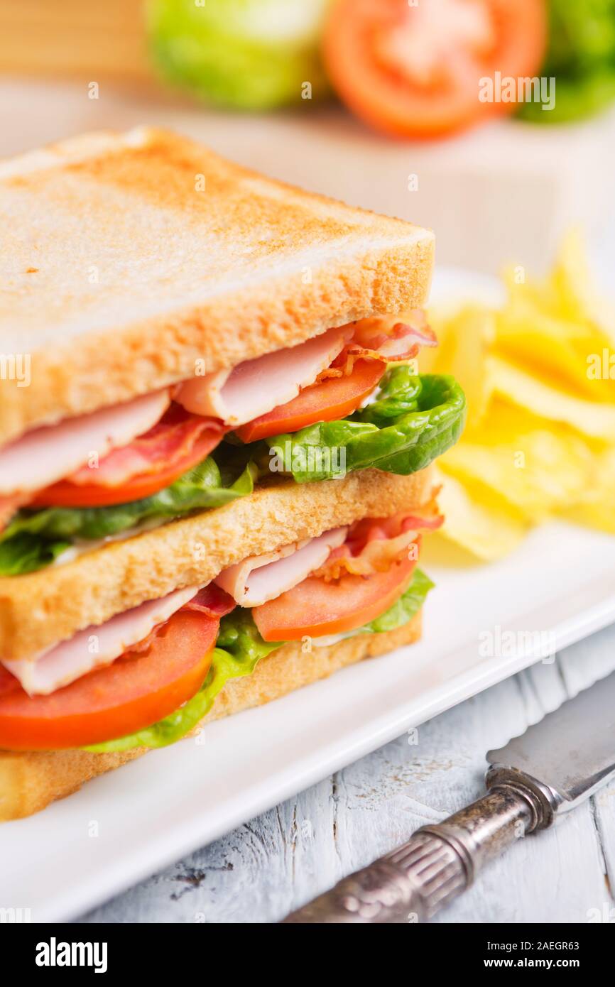 A club sandwich on a rustic table in bright light Stock Photo - Alamy
