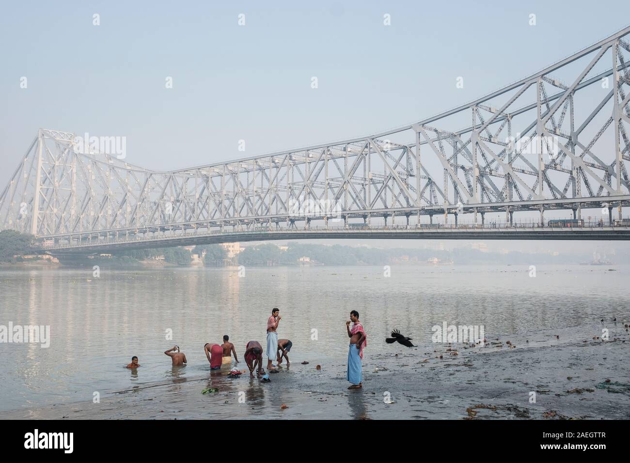 Early morning bath on Howrah river, Kolkata, India. On background the ...
