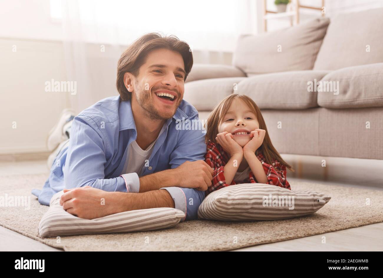 Happy family father and daughter watching TV on floor Stock Photo - Alamy