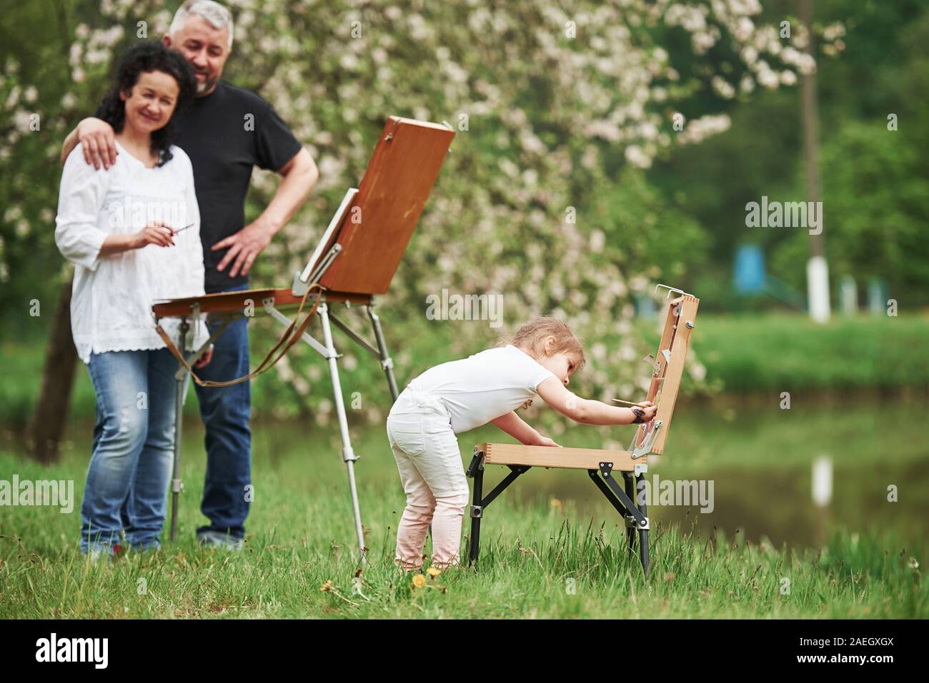 Grandmother and grandfather have fun outdoors with granddaughter ...
